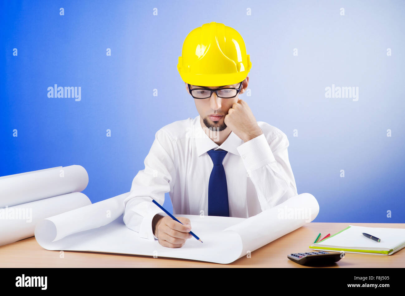 Young engineer looking at drawings Stock Photo - Alamy
