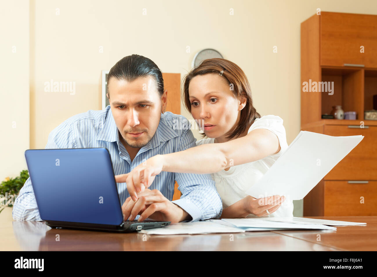 wistful couple calculating budget at home interior Stock Photo - Alamy