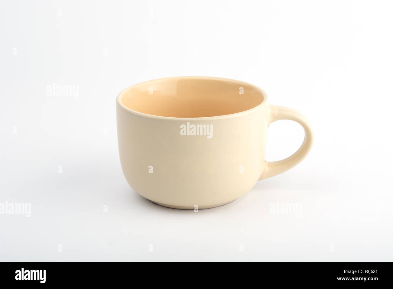 Cup beige color on white background Stock Photo - Alamy