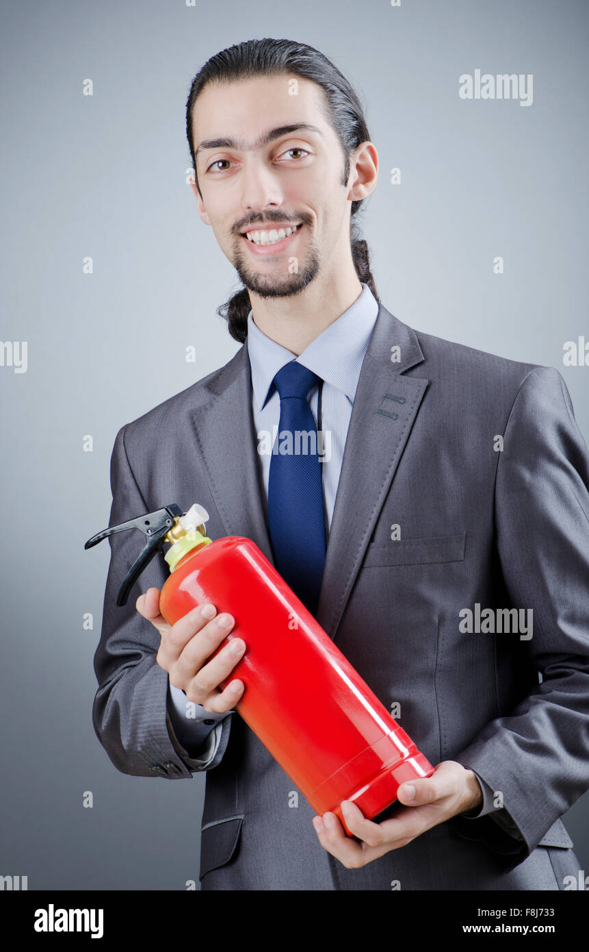 Man with fire extinguisher in firefighting concept Stock Photo - Alamy