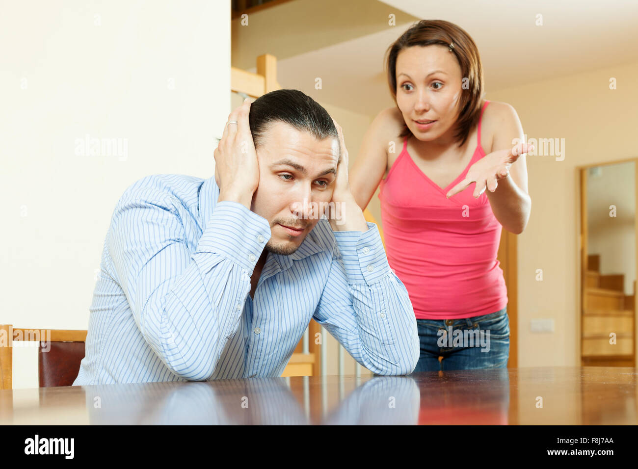 Family quarrel. Tired man listening to his angry wife at home Stock ...