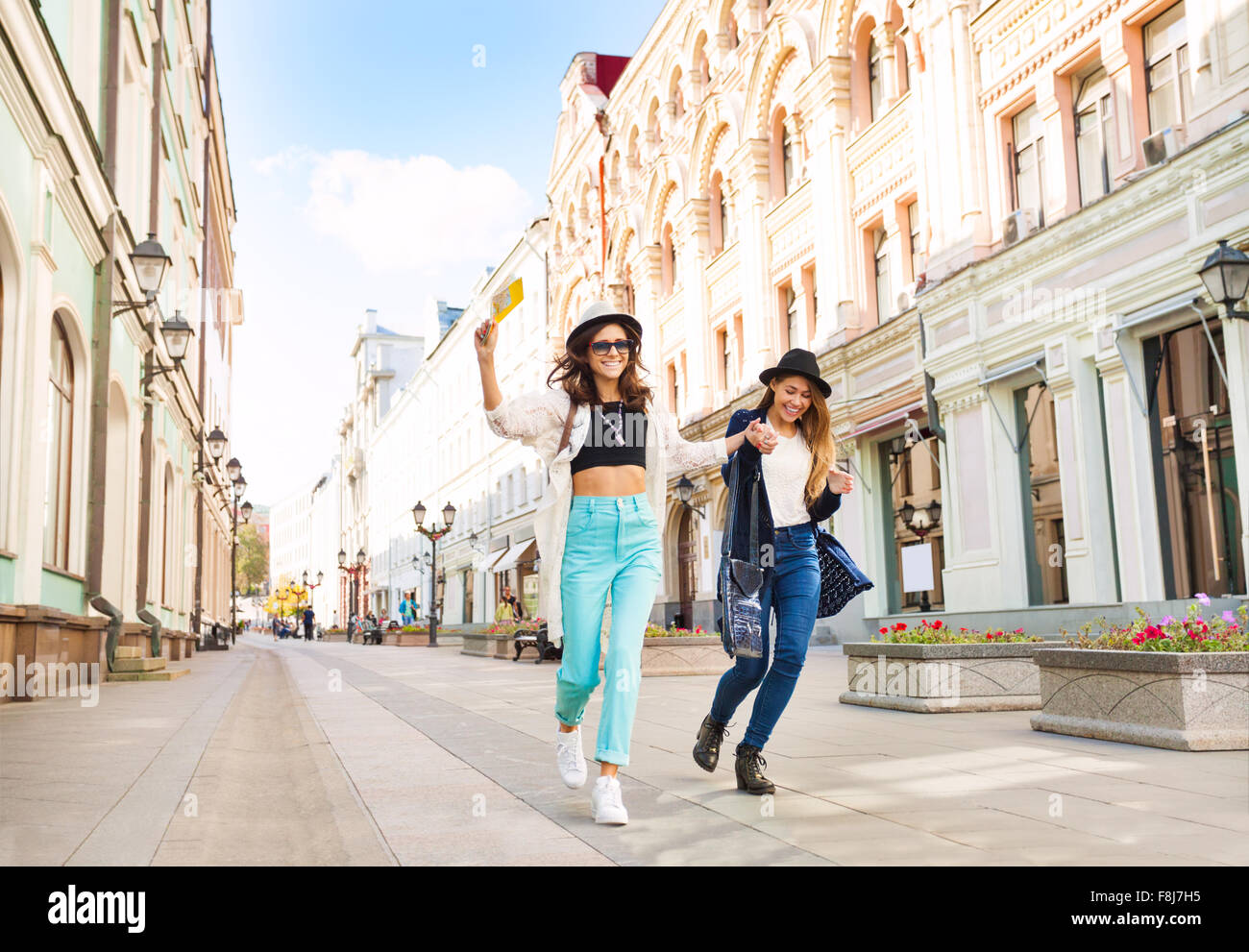 Two happily jumping girls while walking Stock Photo - Alamy