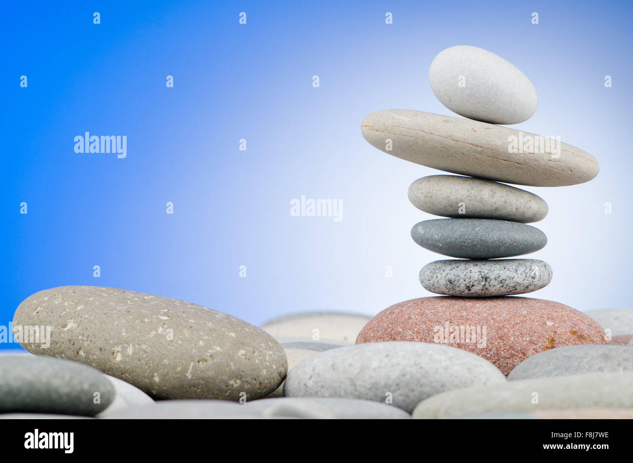 Pebbles stack against gradient background Stock Photo - Alamy