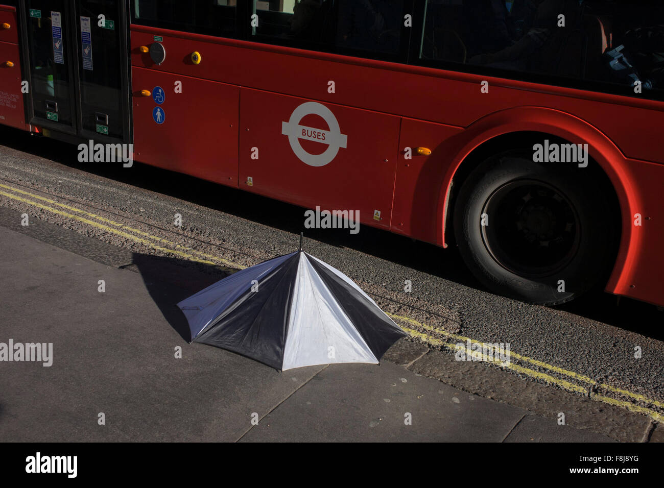 A discarded broken umbrella and side of a bus in Charing Cross Road ...
