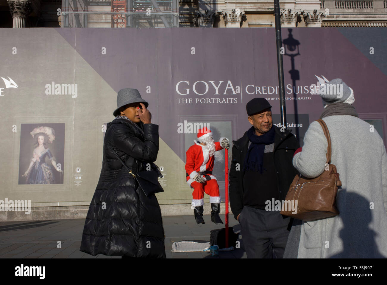A busker dressed as Santa with visitors to Trafalgar Square, central ...
