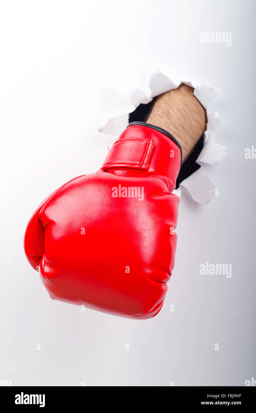 Hand in boxing glove through paper hole Stock Photo - Alamy