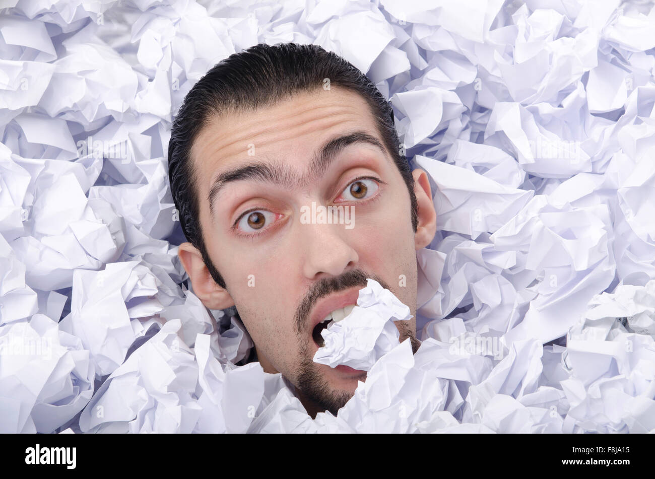 Man with lots of crumpled paper Stock Photo - Alamy