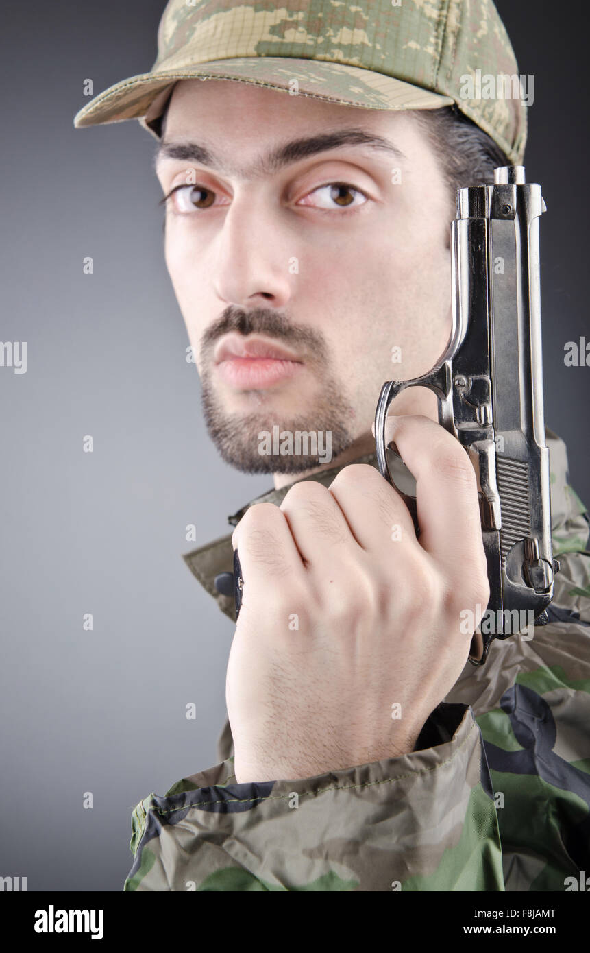 Soldier with gun in studio shooting Stock Photo - Alamy