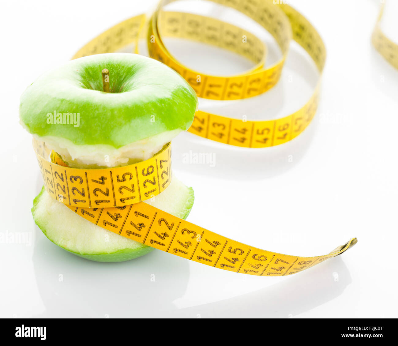Green apple core and measuring tape Stock Photo - Alamy