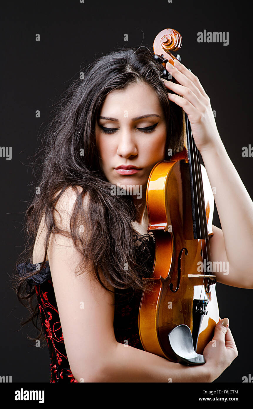 Female violin player against background Stock Photo - Alamy