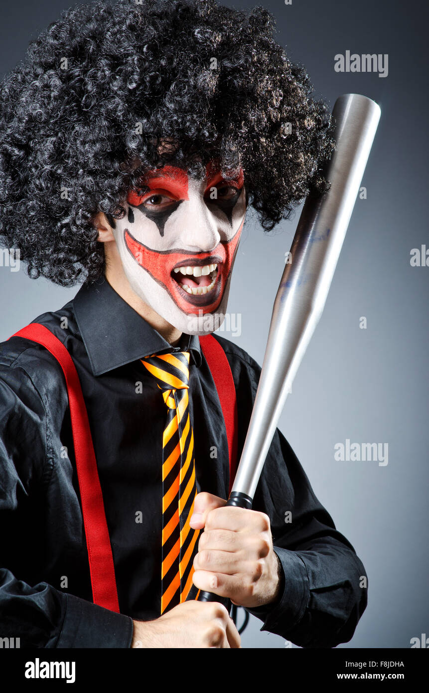 Funny clown with bat in studio Stock Photo - Alamy