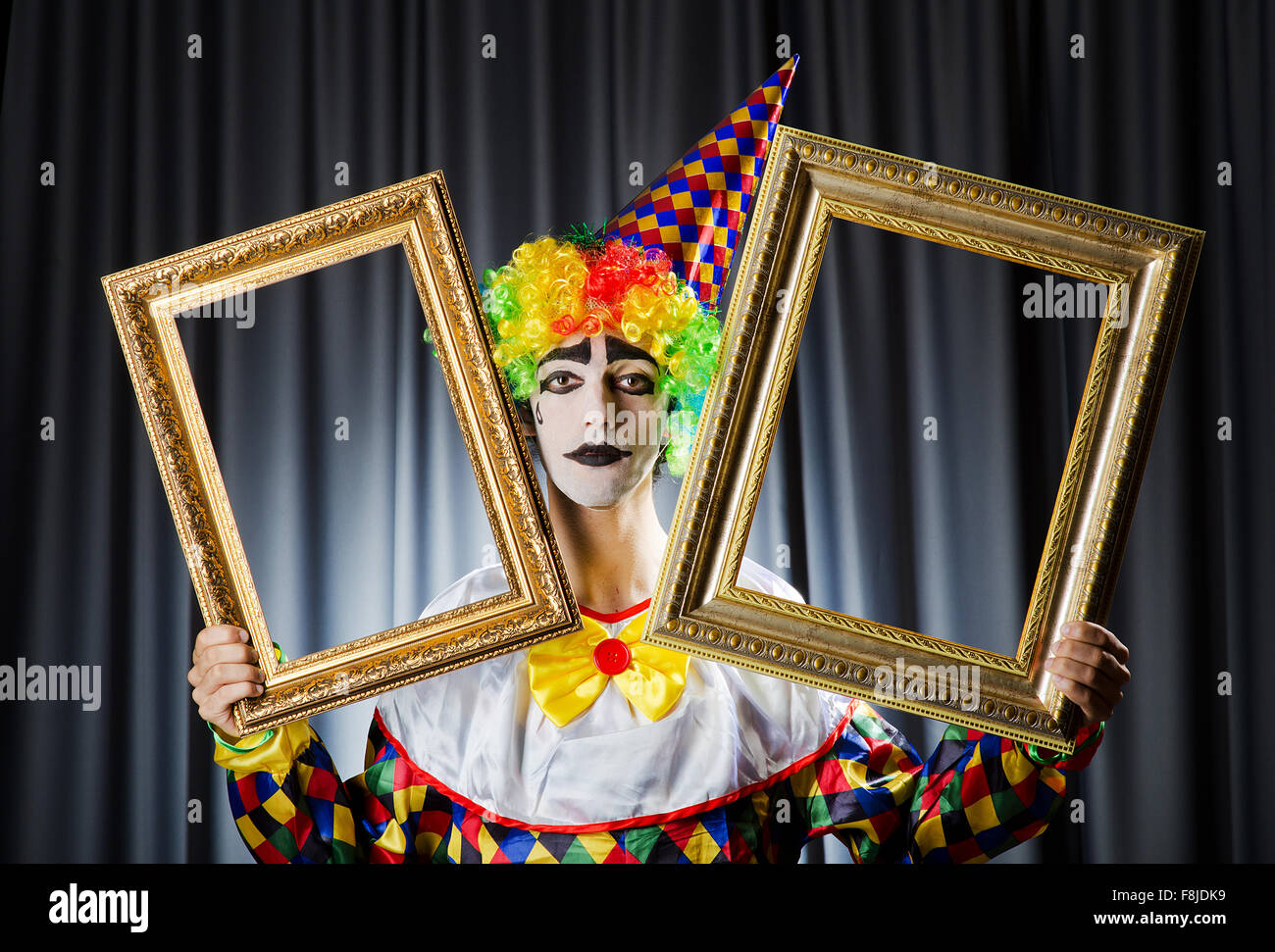 Clown with picture frames in studio Stock Photo - Alamy