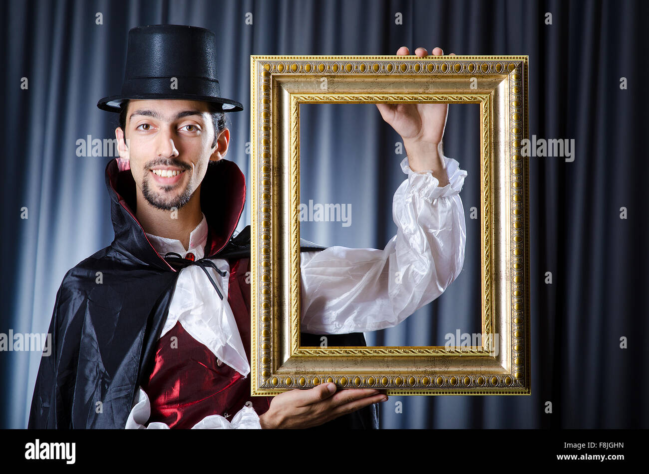 Magician with photoframe in studio Stock Photo - Alamy