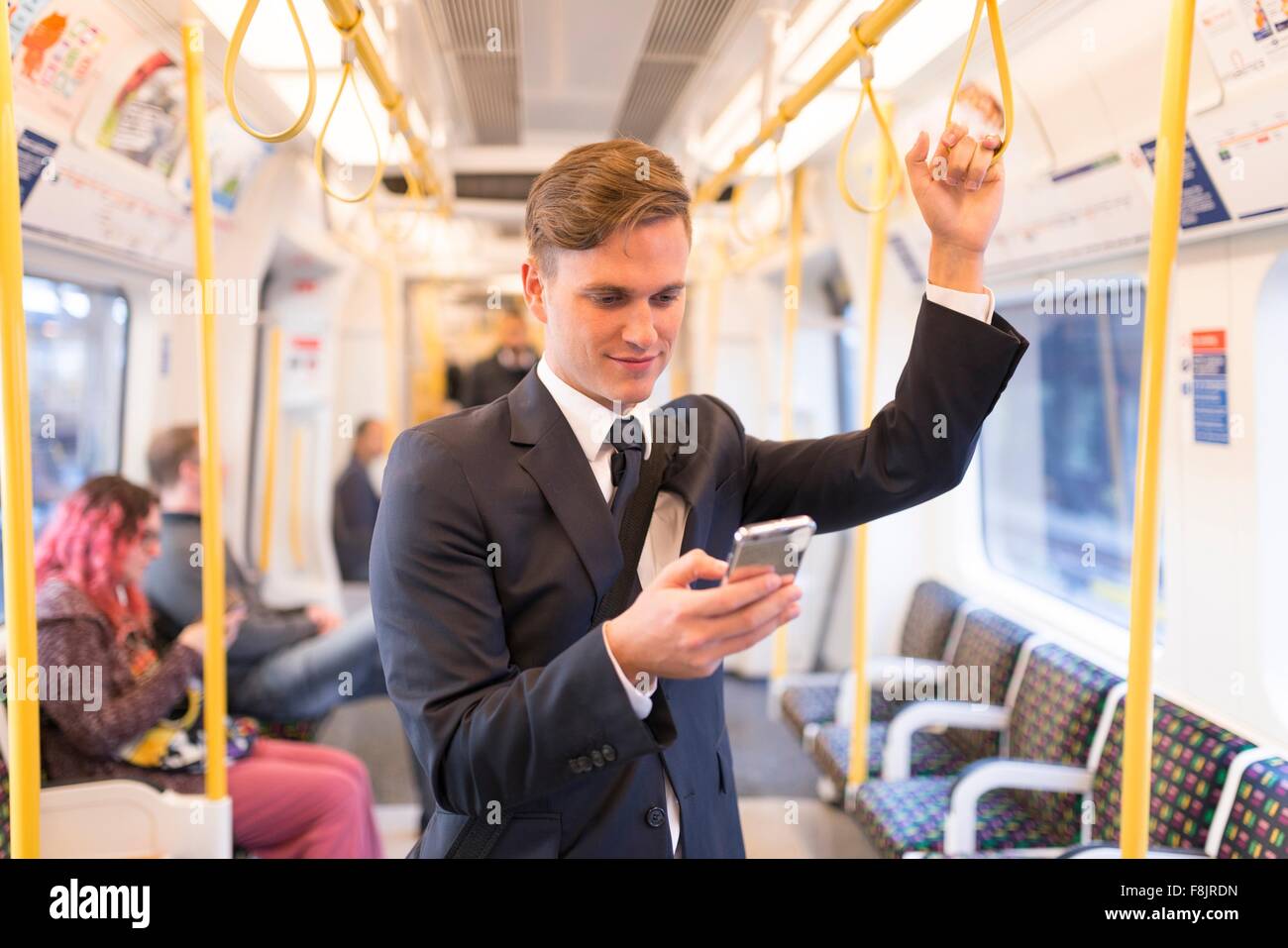 Businessman texting on tube, London Underground, UK Stock Photo - Alamy