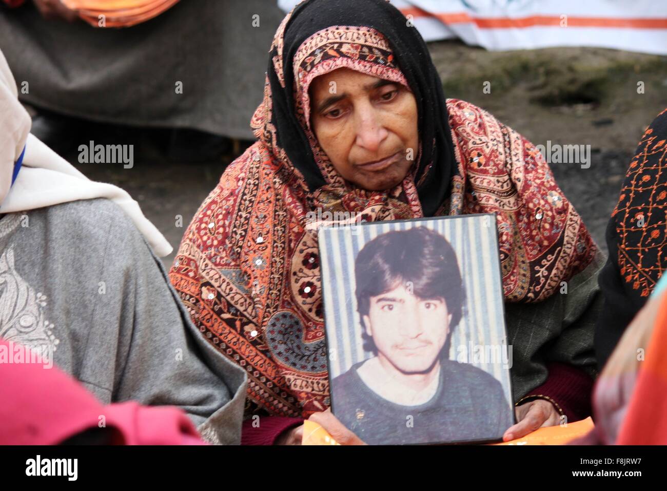 A Kashmiri Muslim woman relative of a missing person hold the pictures ...