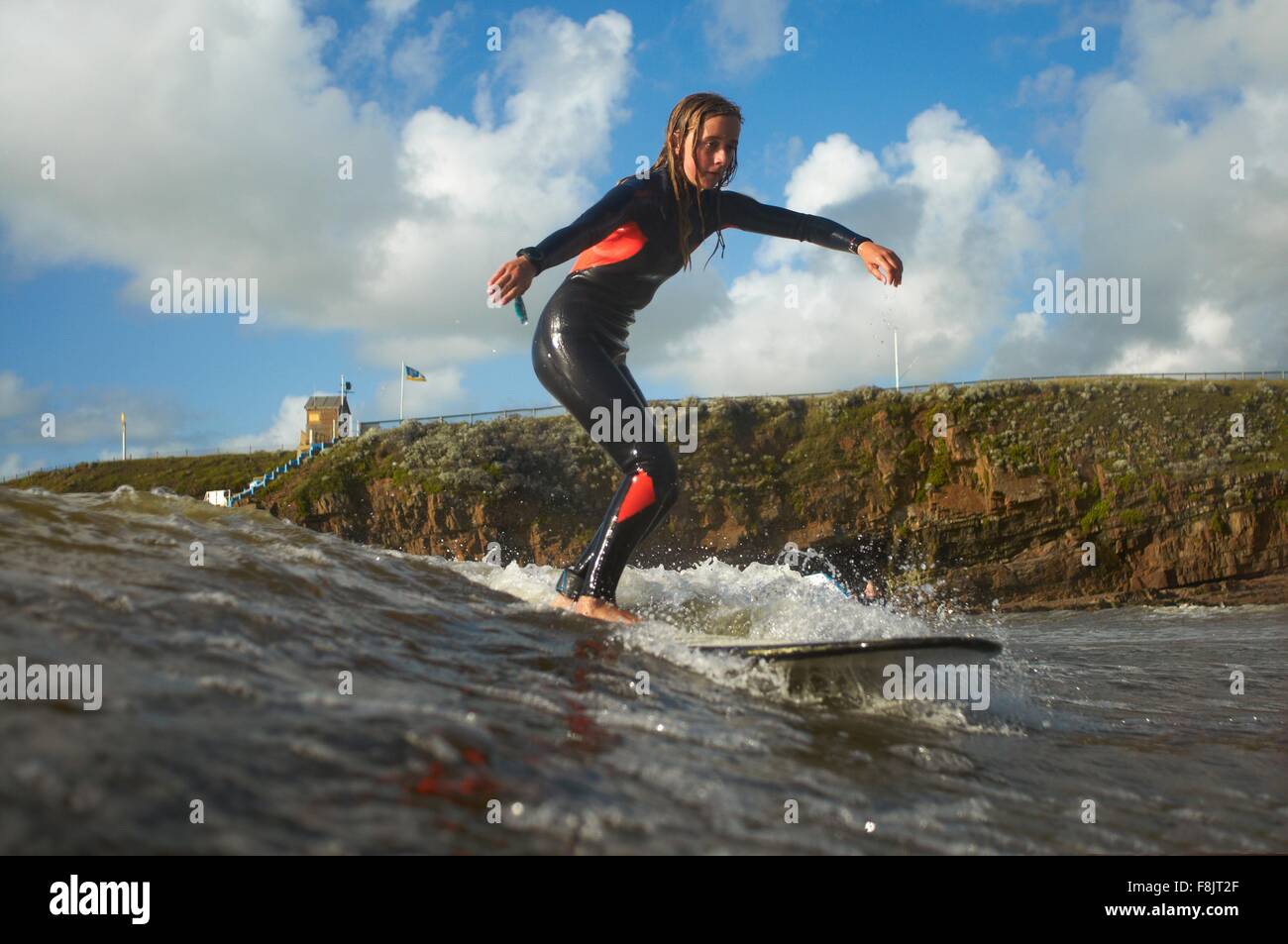 Young female surfer riding wave Stock Photo - Alamy