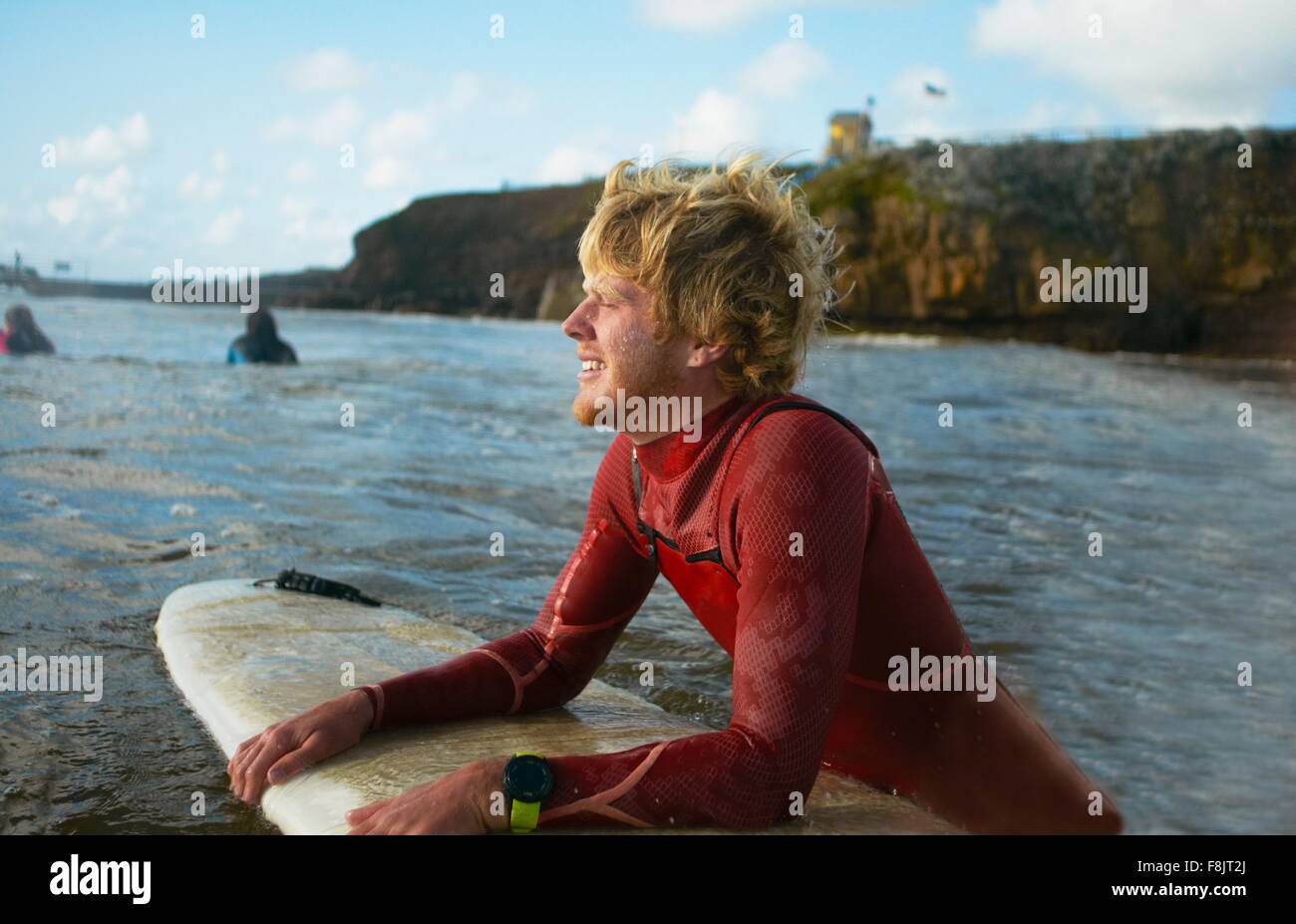 Male surfer in sea, holding surfboard, resting Stock Photo - Alamy