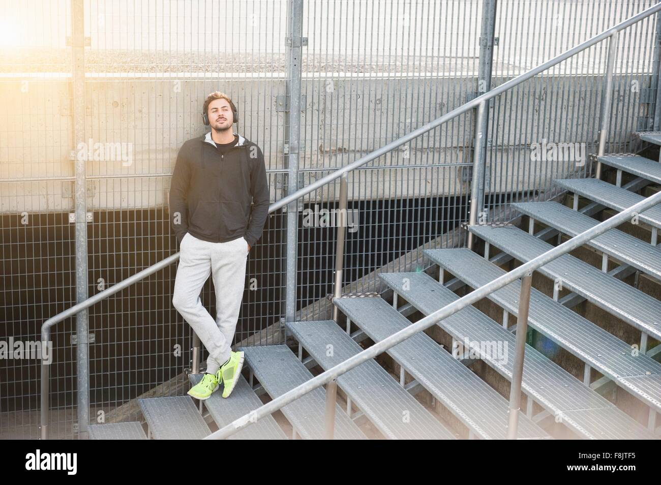 Young male runner leaning against sport arena stairway Stock Photo - Alamy