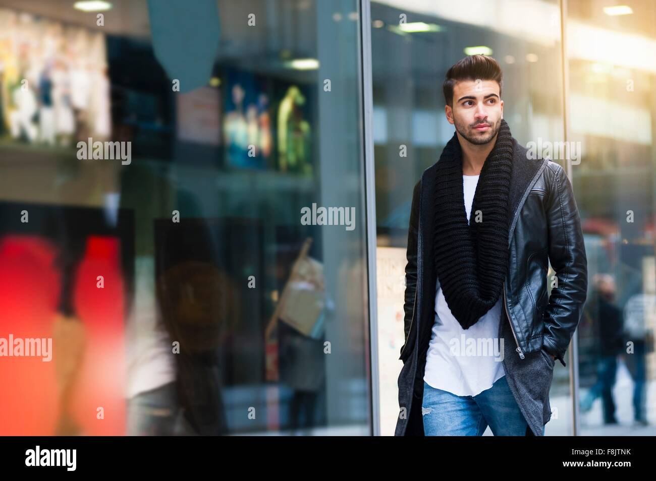 Young man passing display window of shop Stock Photo - Alamy