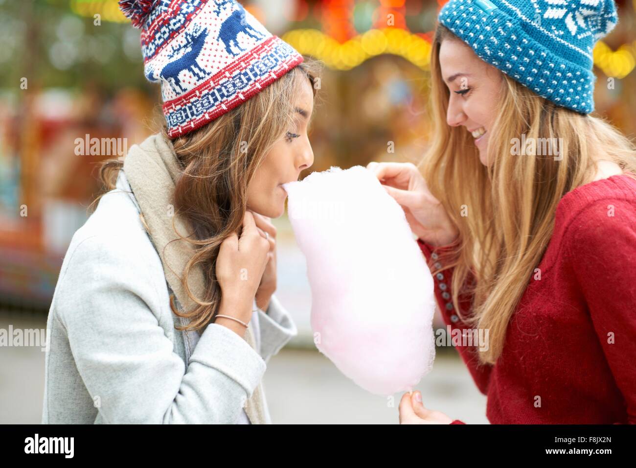 Two young women eating candy floss at funfair, outdoors Stock Photo - Alamy