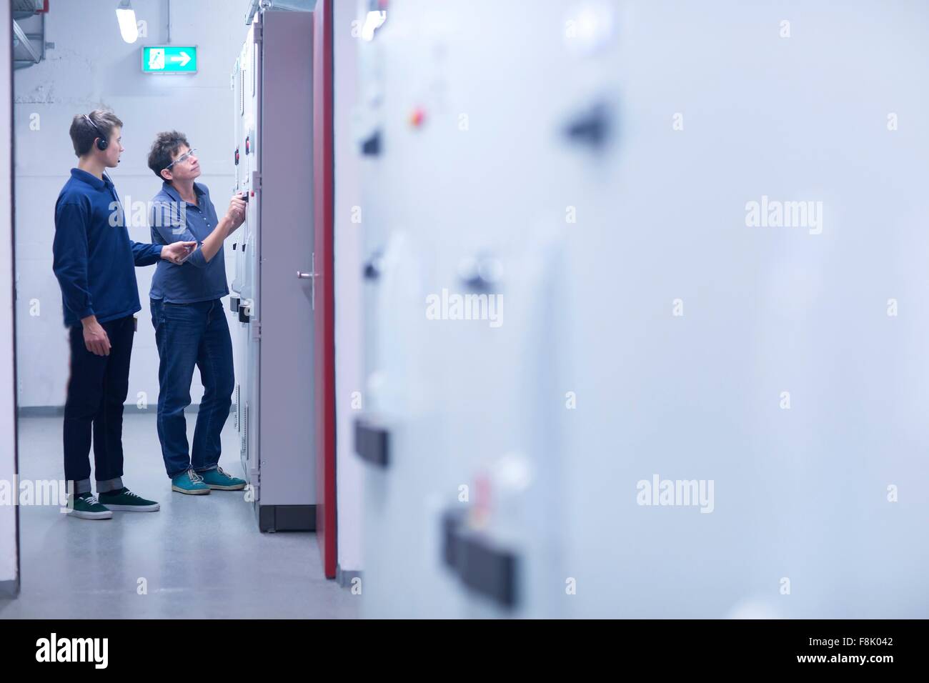 Colleges in control room looking at switchgear Stock Photo - Alamy