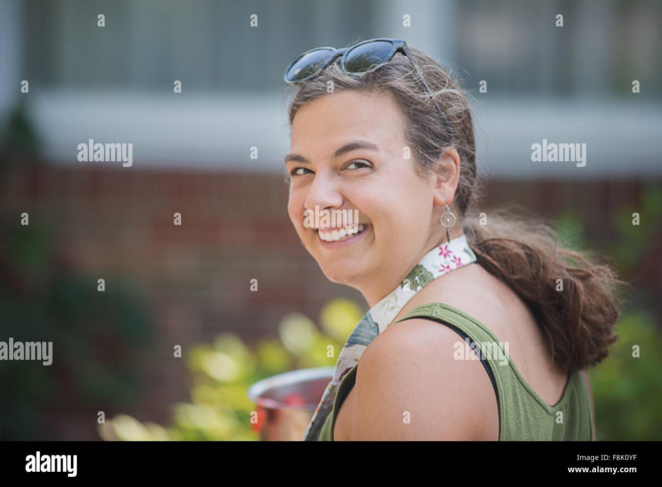 Portrait of woman looking over shoulder at camera smiling Stock Photo ...
