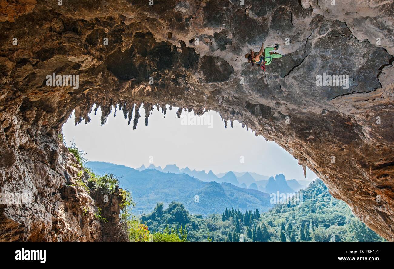 Female climber climbing Odin's Dan - a limestone cliff in Yangshuo ...