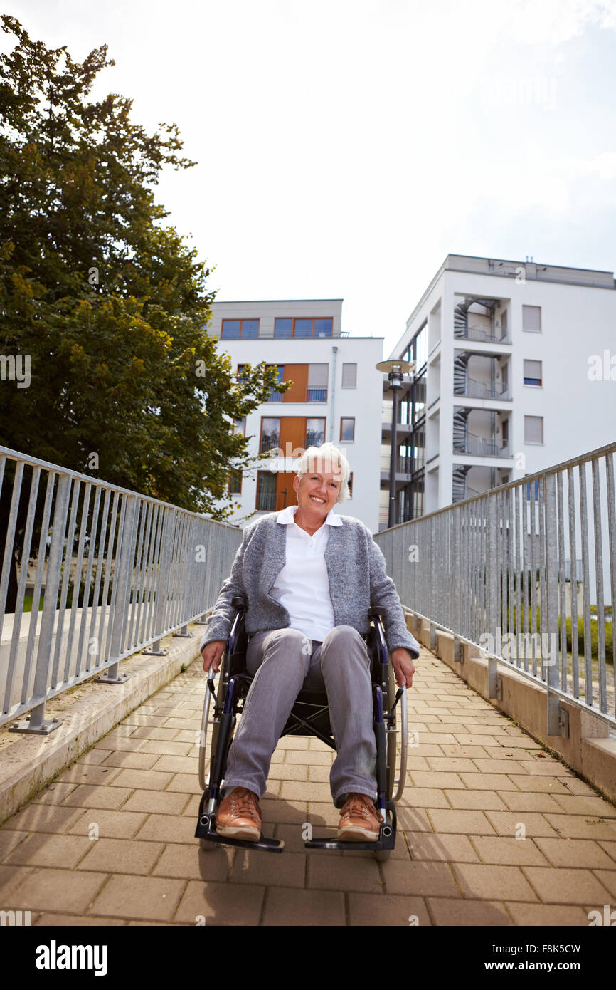 Happy elderly woman in wheelchair using a ramp Stock Photo - Alamy