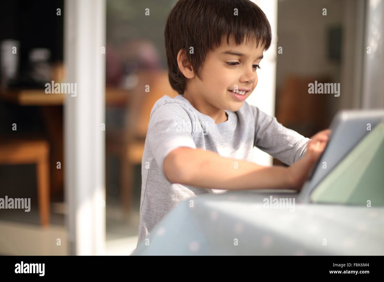 Boy using digital tablet smiling Stock Photo - Alamy