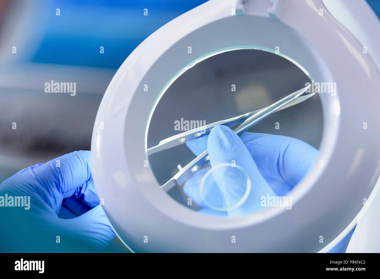 Worker inspecting surgical instruments in clean room of surgical ...