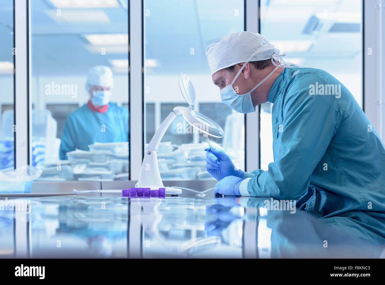 Workers inspecting surgical instruments in clean room of surgical ...