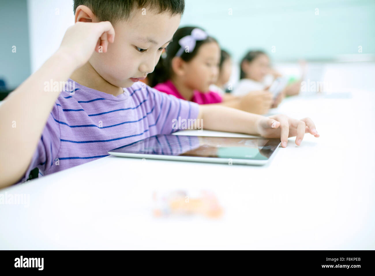 Boy sitting with girl using digital tablet in classroom Stock Photo - Alamy