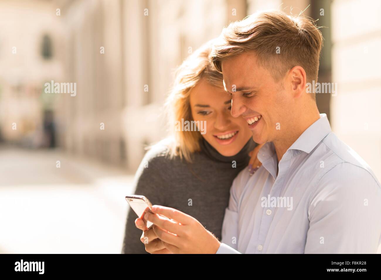 Couple sharing text message in street Stock Photo - Alamy
