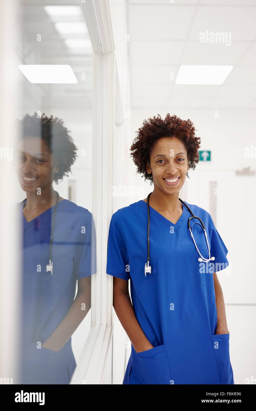 Doctor leaning against glass window in hospital Stock Photo - Alamy