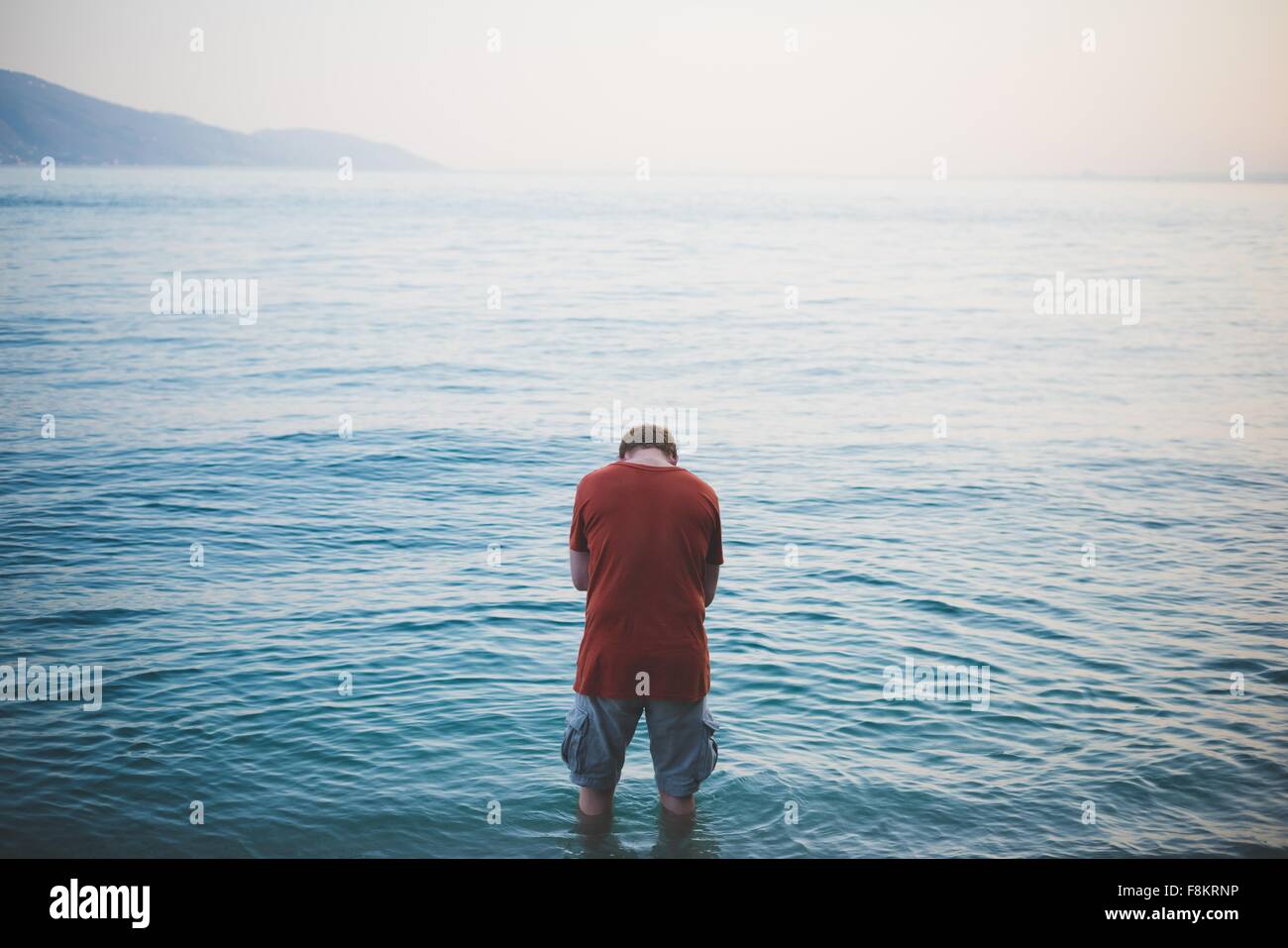 Man with head down standing in Lake Garda, Italy Stock Photo - Alamy