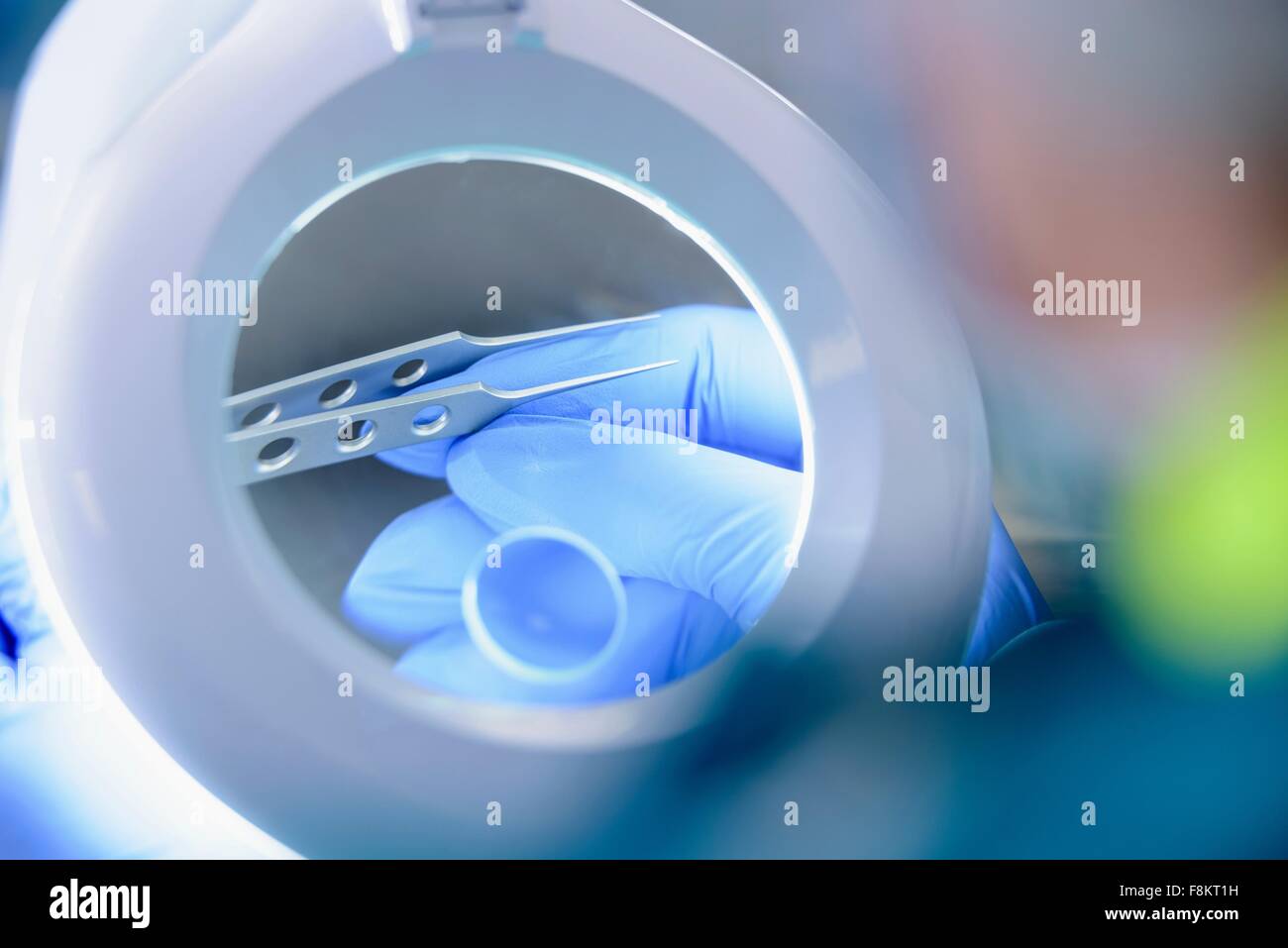 Worker inspecting surgical instruments in clean room of surgical ...