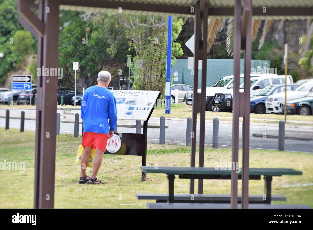 Man reading sign at city park Stock Photo - Alamy