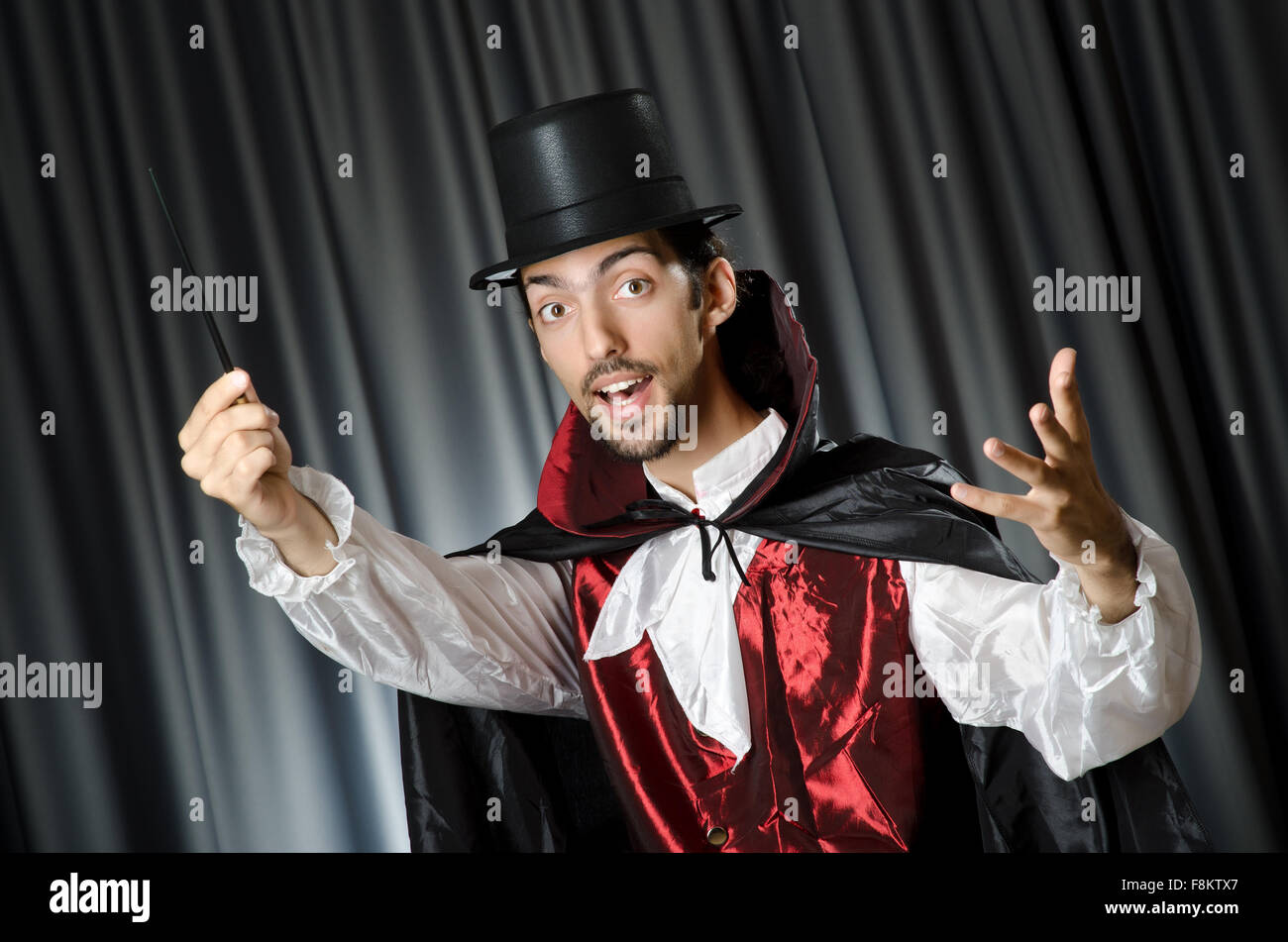 Magician doing tricks on white Stock Photo - Alamy