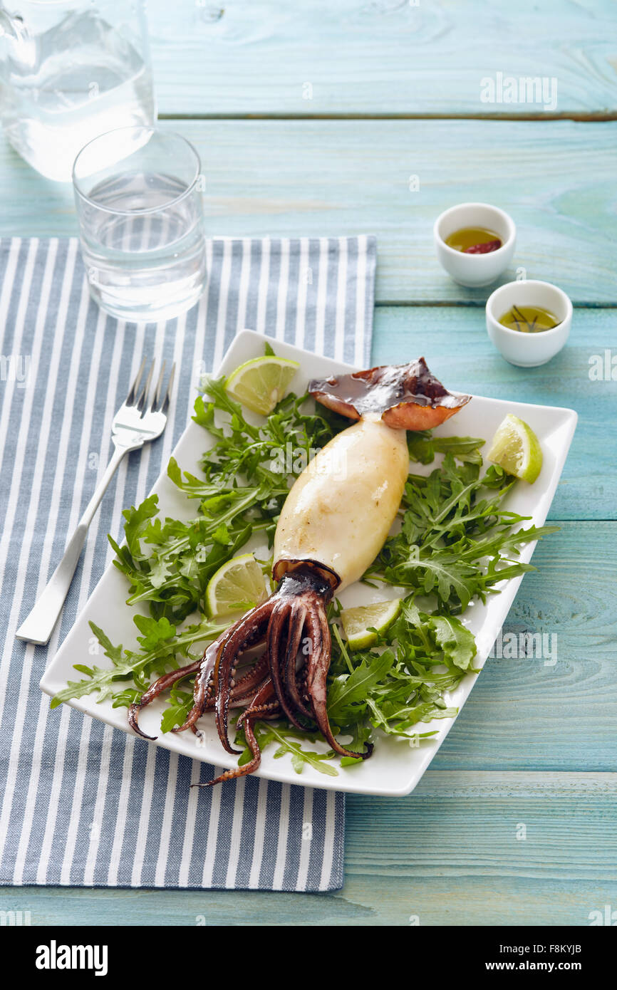 Grilled squid with rocket salad and lemon Stock Photo - Alamy