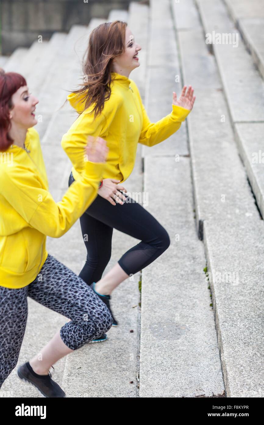 Young women running up steps Stock Photo - Alamy