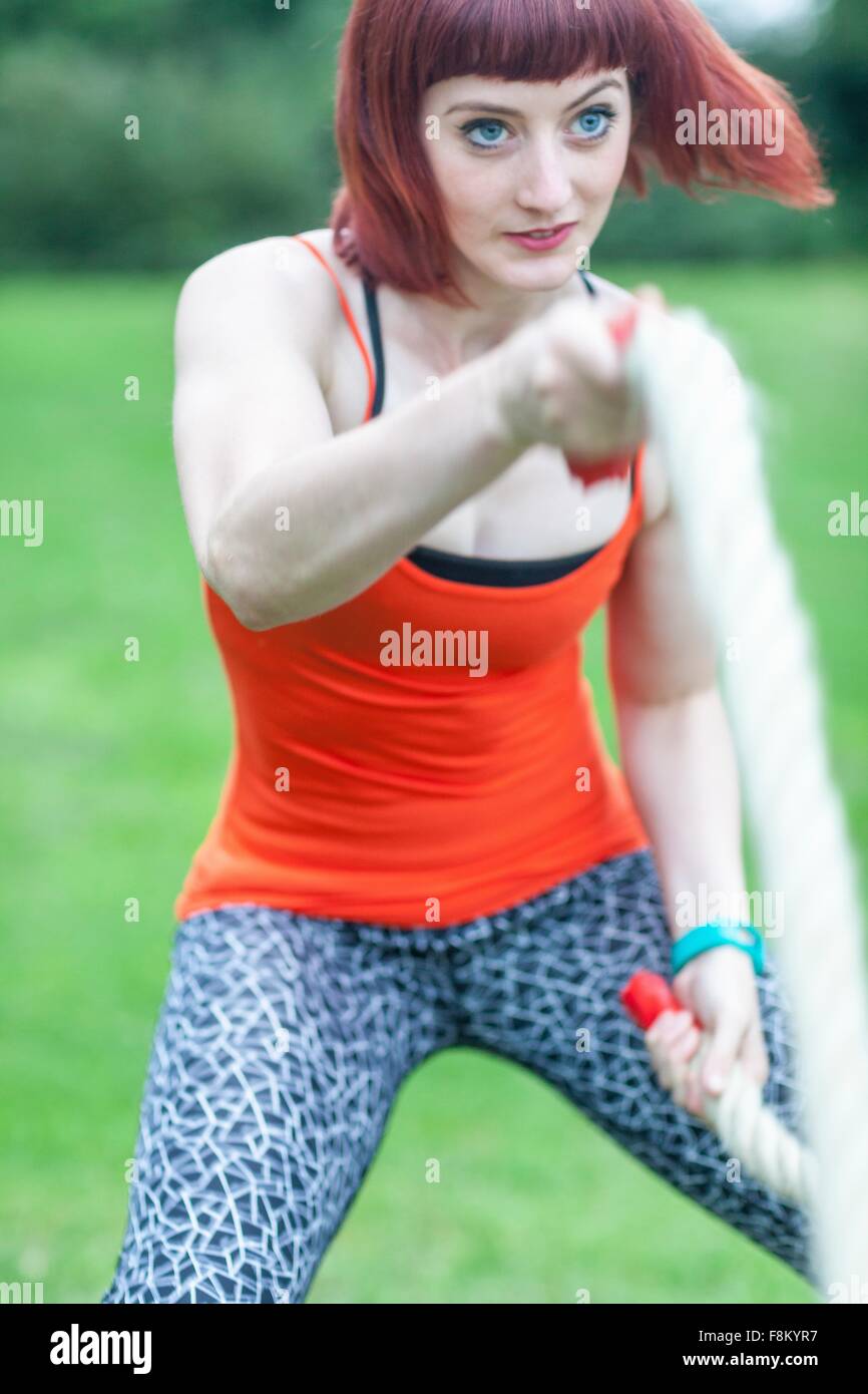 Young woman pulling rope on field Stock Photo - Alamy