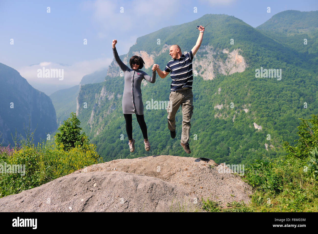 happy young couple in love jump in air in beautiful green and fresh ...