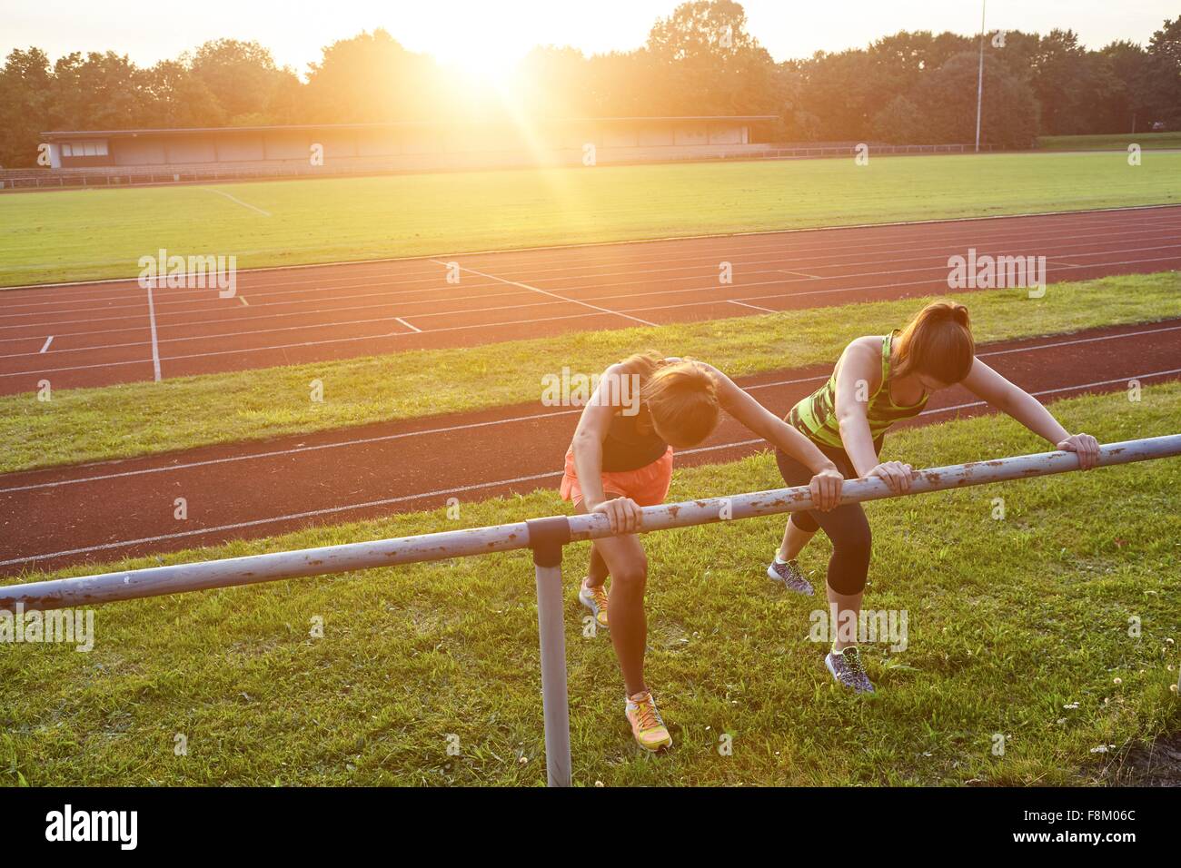 Two young women training on handrail at race track Stock Photo - Alamy
