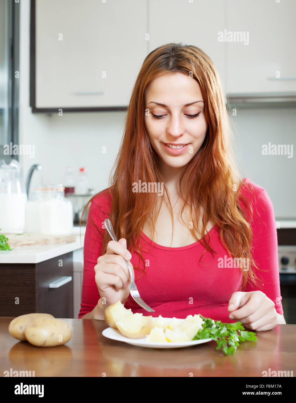 woman in red eating jacket potatoes at home Stock Photo - Alamy