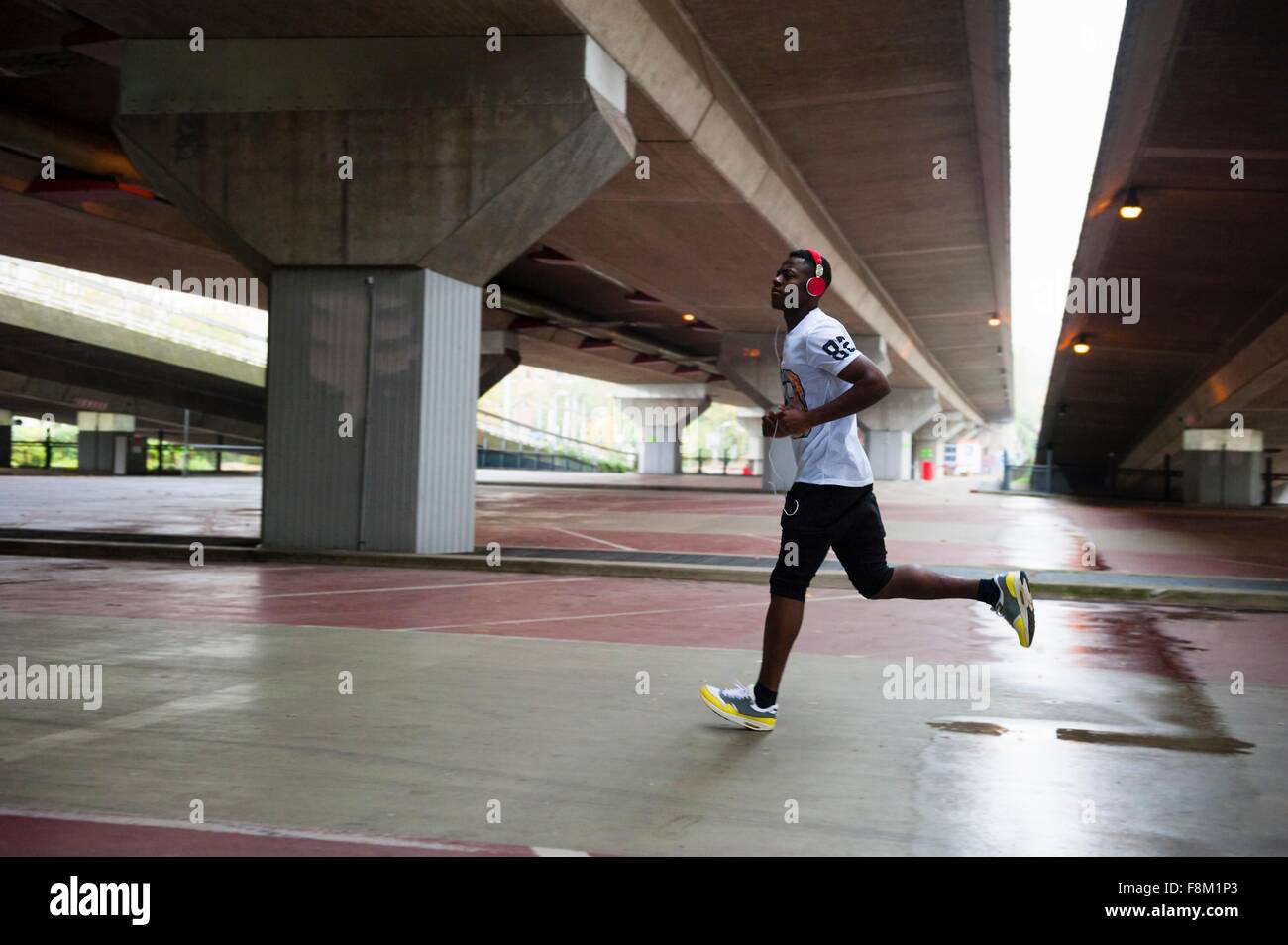 Young man running in urban environment Stock Photo - Alamy