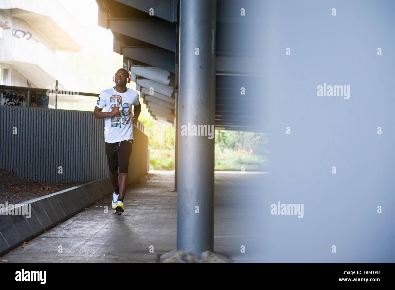 Young man running in urban environment Stock Photo - Alamy