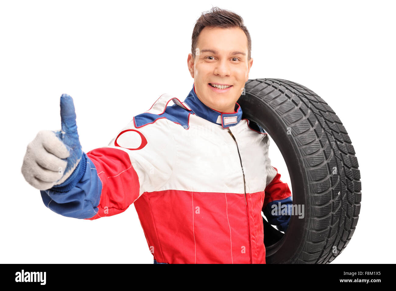 Young male car racer holding a tire and giving a thumb up isolated on ...