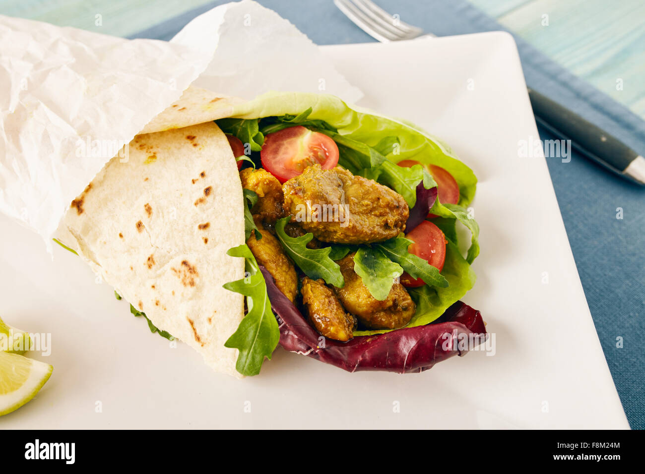 pork wraps on a white serving plate with rocket and lettuce, pastel ...