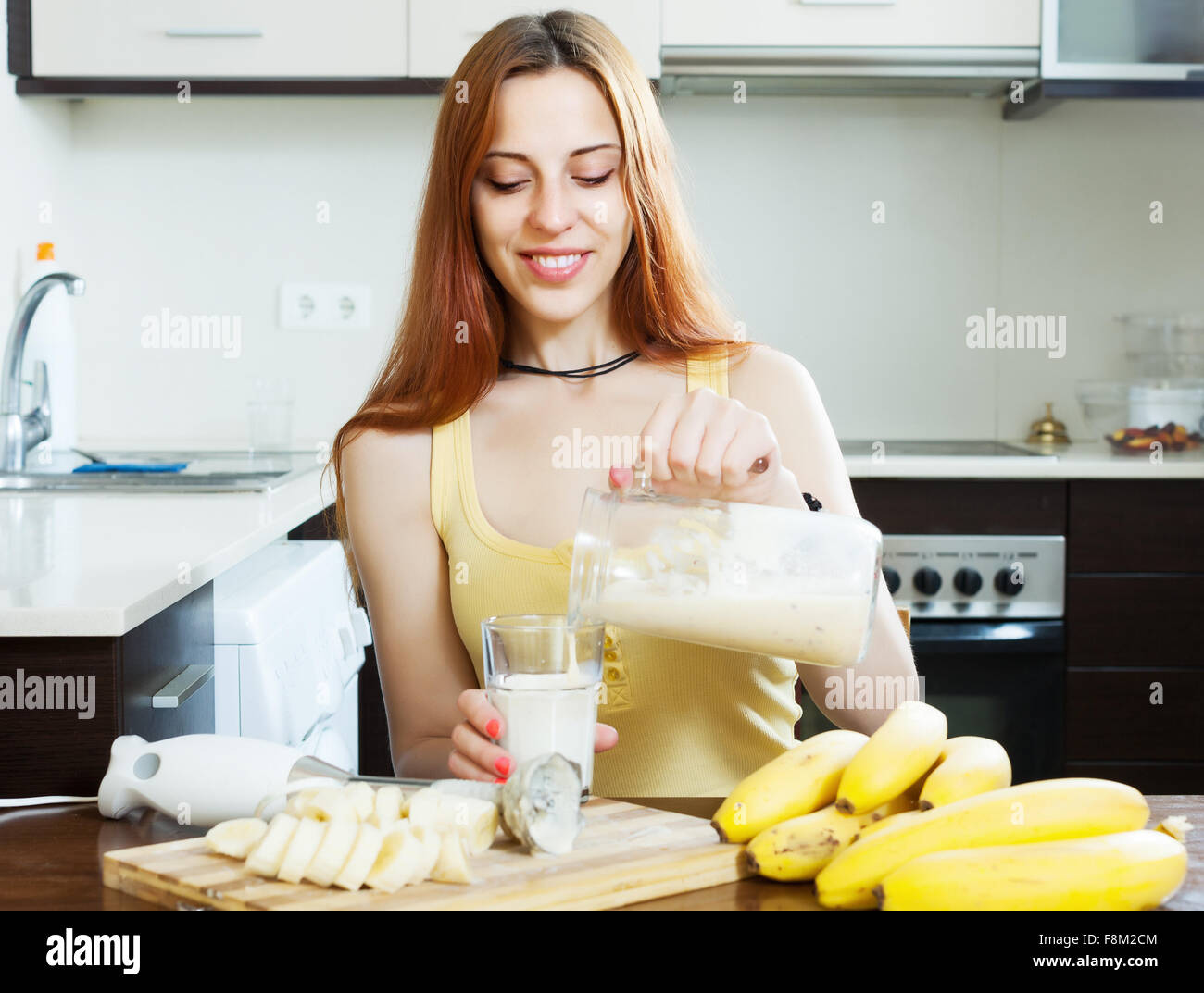 woman pouring milk shake with bananas at home kitchen Stock Photo - Alamy