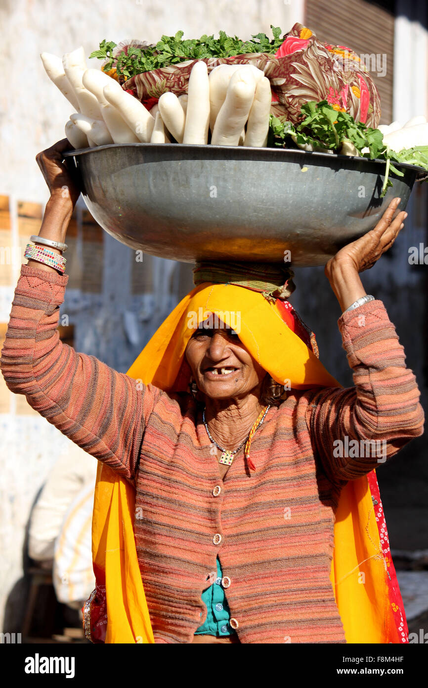 PUSHKAR, INDIA - NOV 29: Old Indian woman selling vegetables in the street of Pushkar with a ...